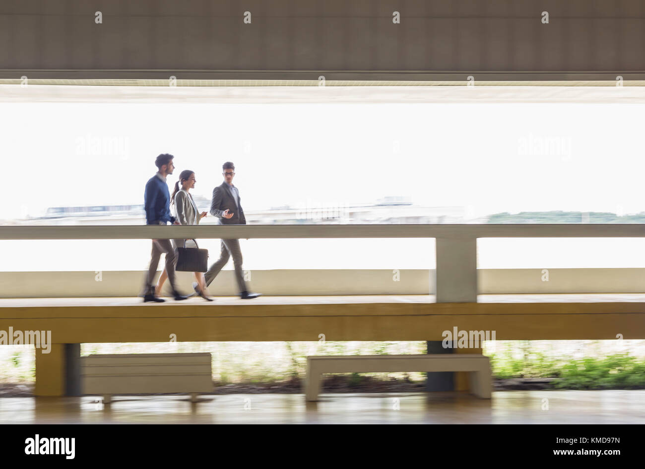Business people walking and talking on elevated walkway in office Stock ...