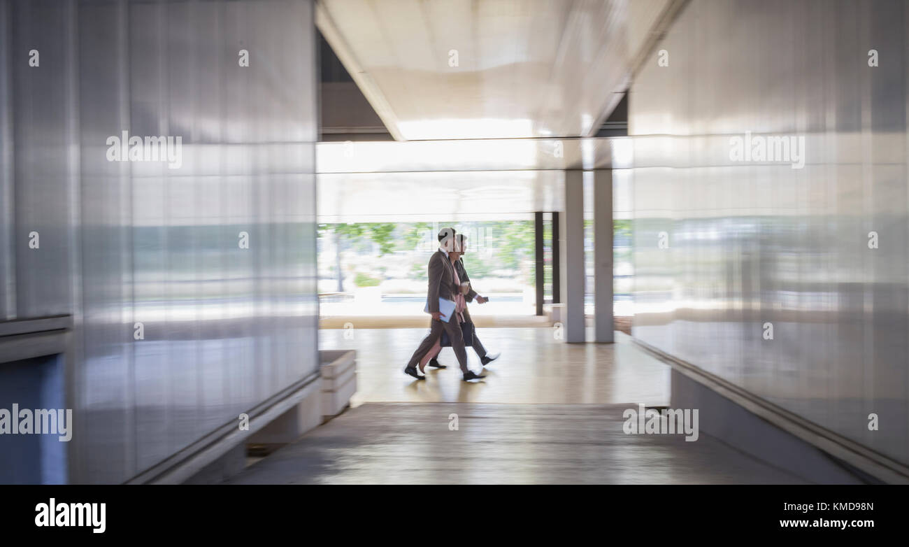 Business people walking in modern office corridor Stock Photo - Alamy