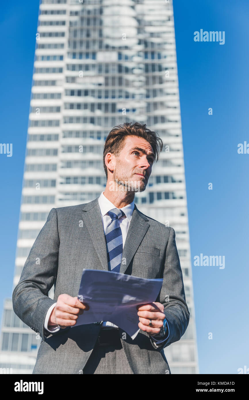 Businessman standing in front skyscraper hi-res stock photography and ...