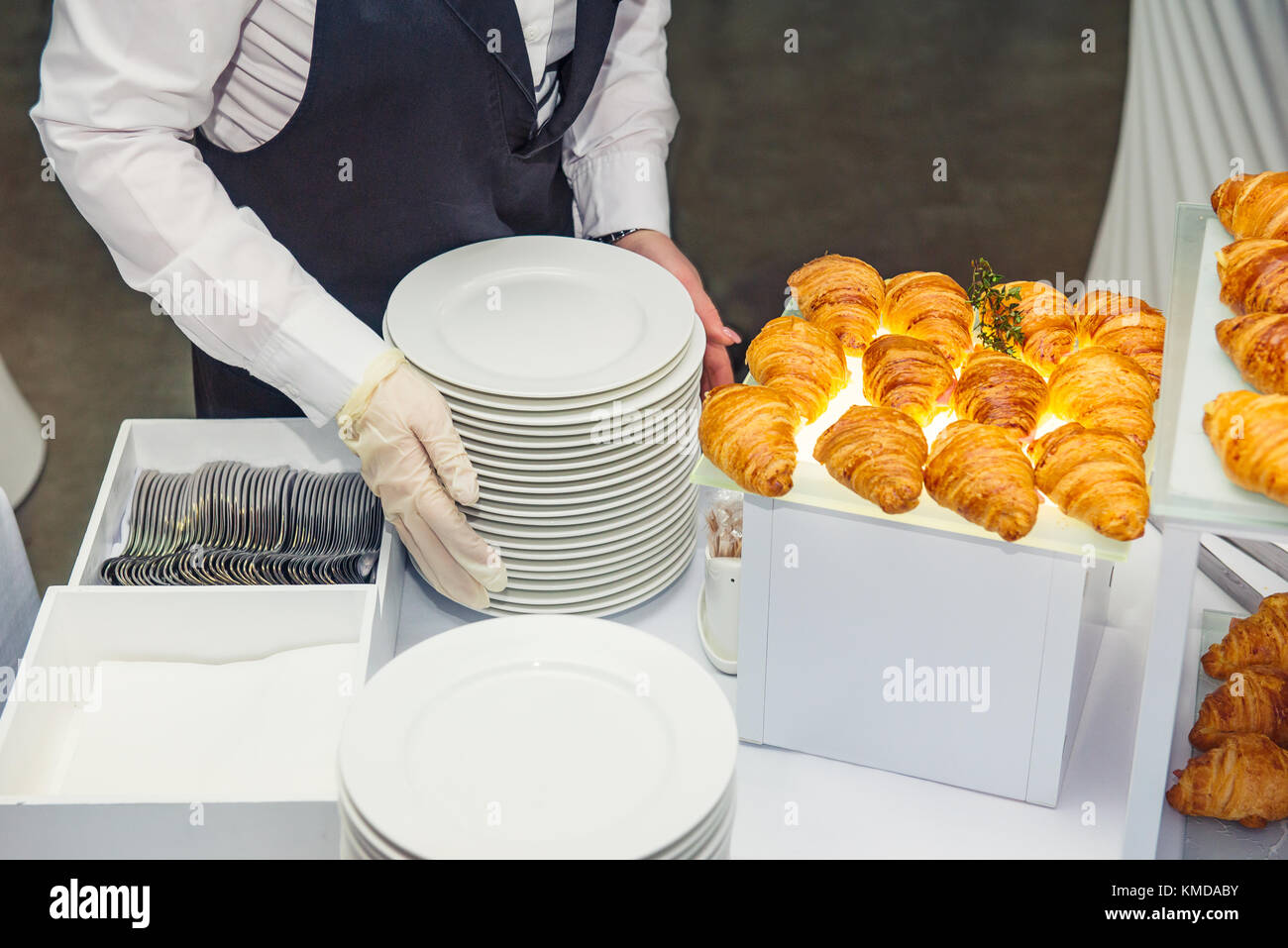 The waiter is servering catering buffet table with food and snacks for ...
