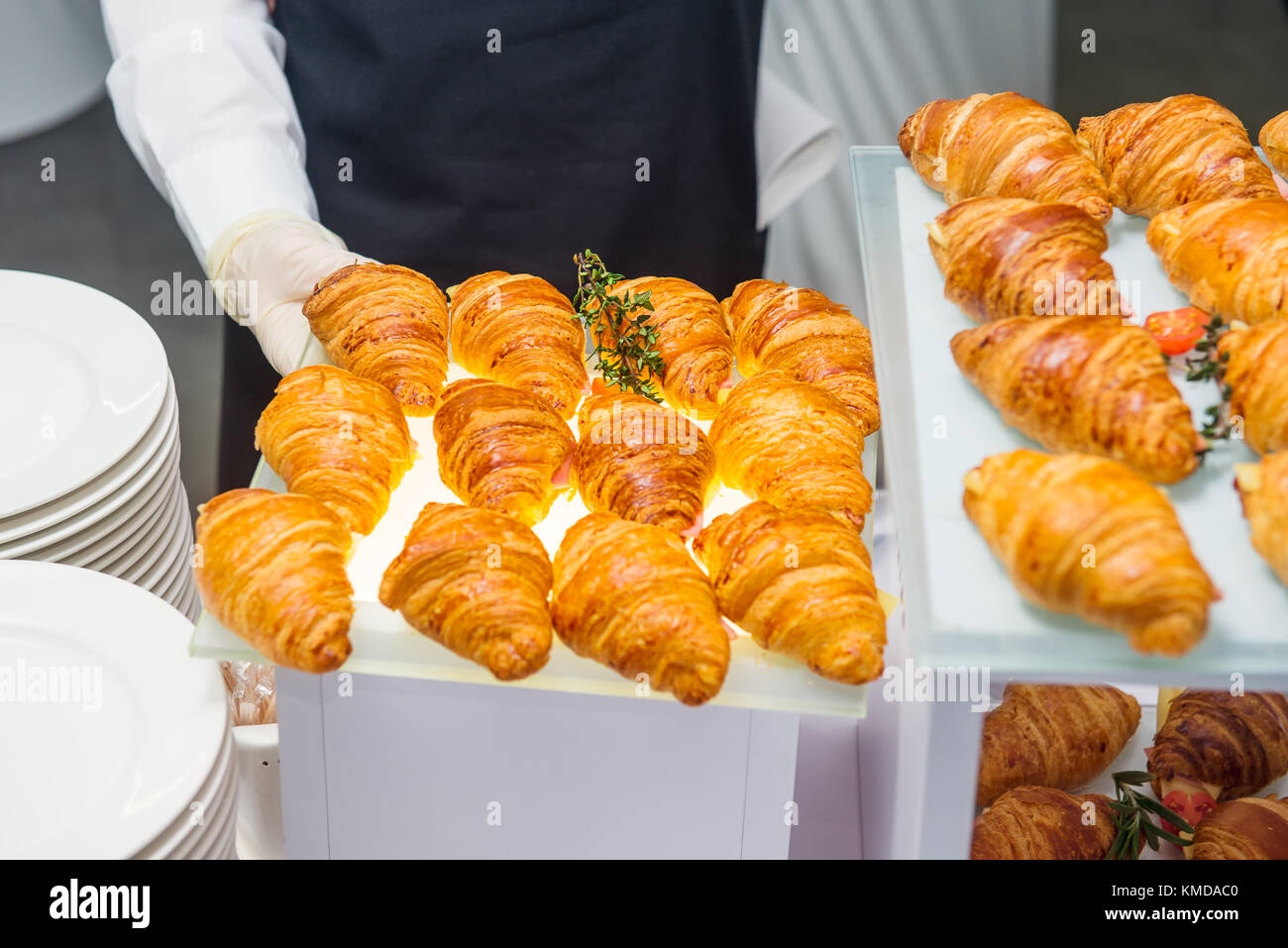 The waiter is servering catering buffet table with food and snacks for ...