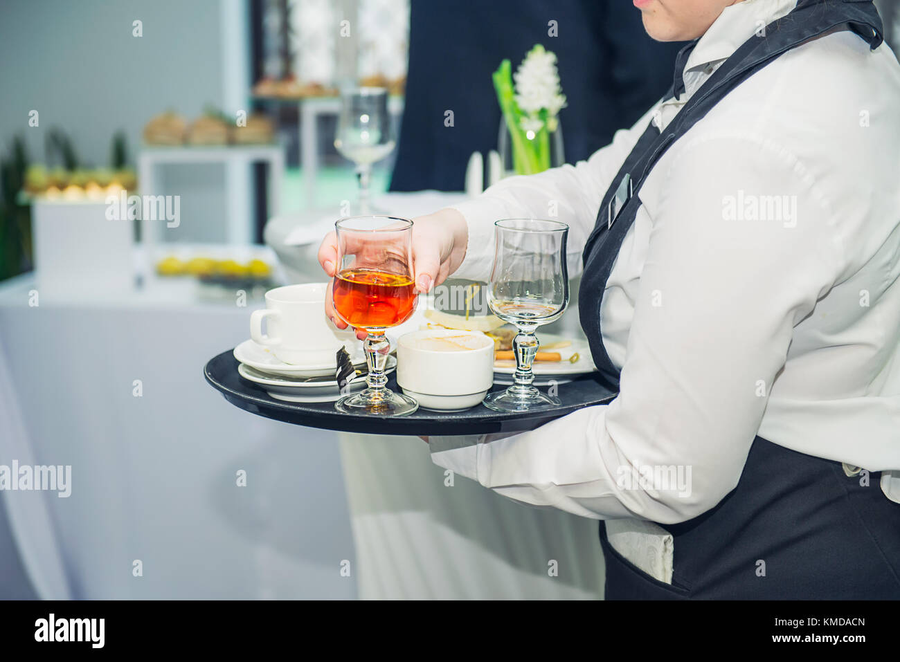 The waiter removes dirty dishes from the tables after guests of the ...
