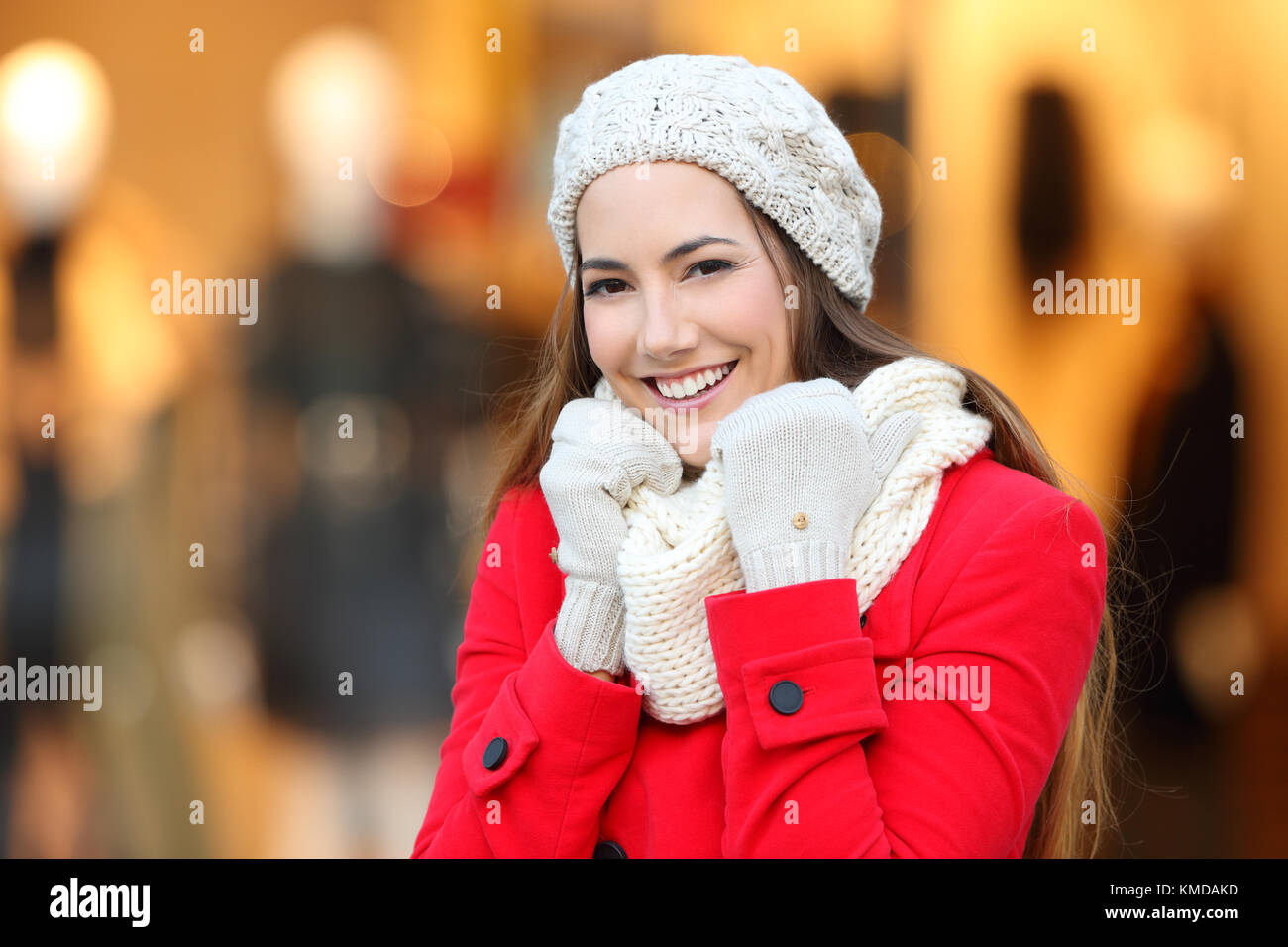 Portrait of a happy woman keeping warm in winter in a mall in winter ...