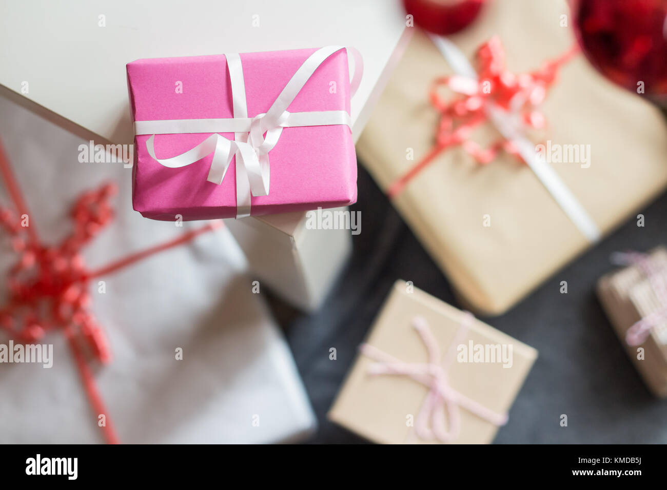 Many self made present boxes on floor, focus on little pink present box ...