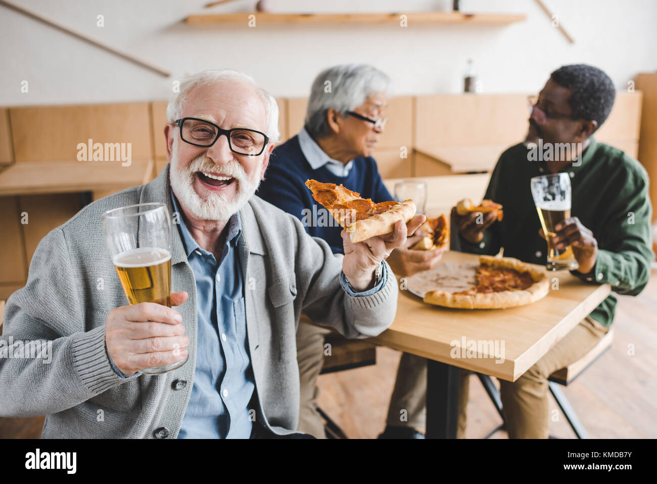 senior man eating pizza with beer Stock Photo - Alamy