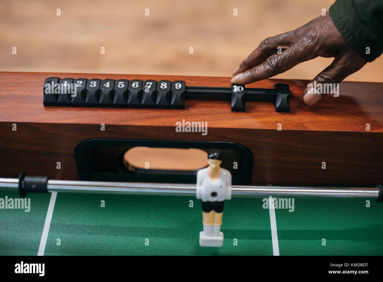 man moving counter on table football Stock Photo - Alamy