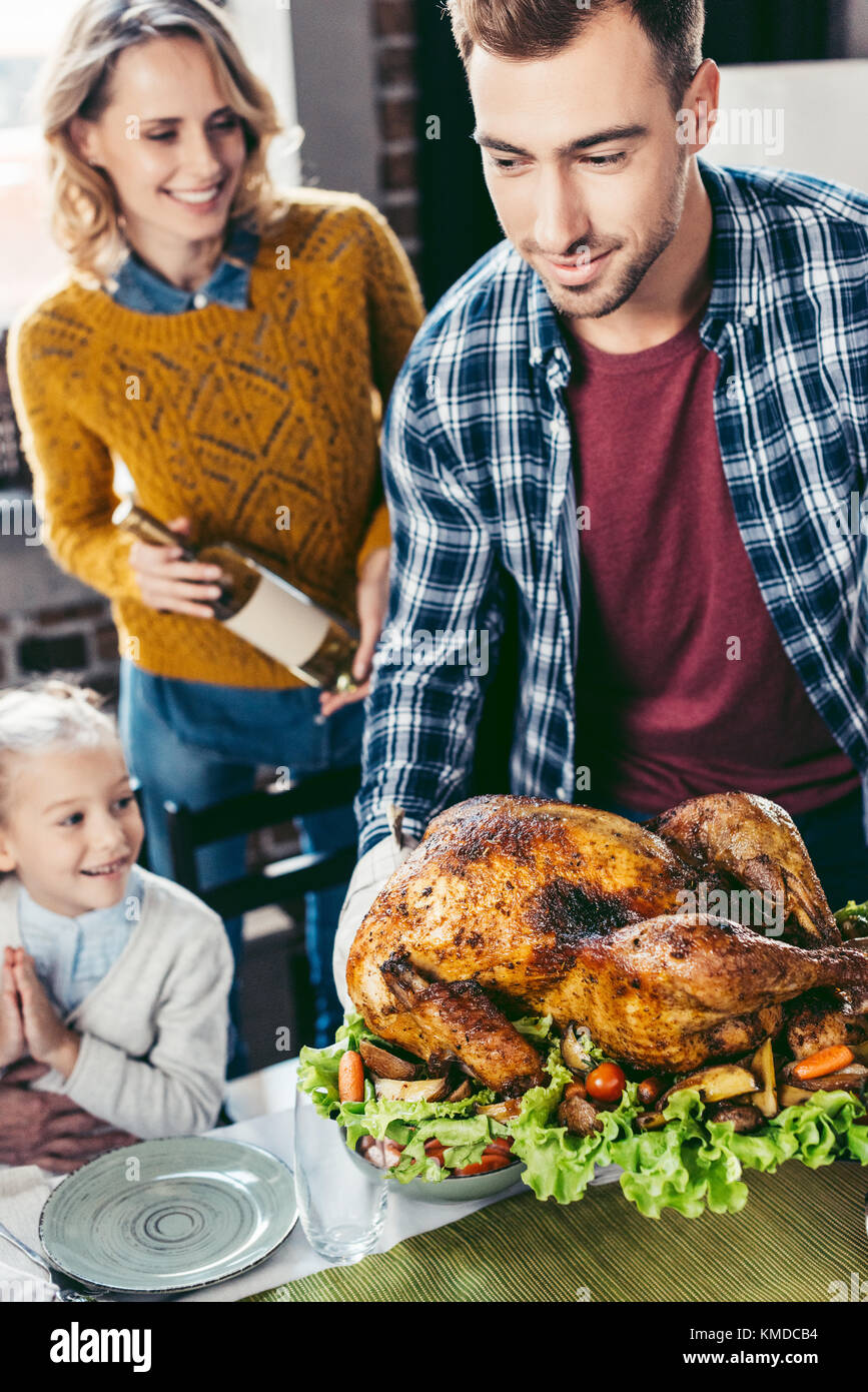 father putting turkey on holiday table Stock Photo - Alamy