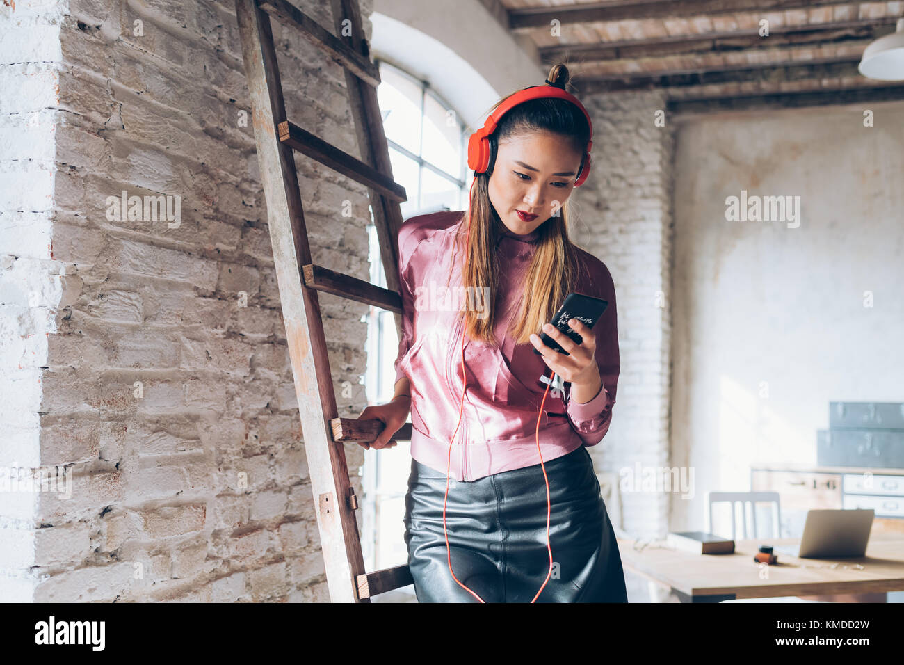 young woman indoors listening music using smart phone - technology ...