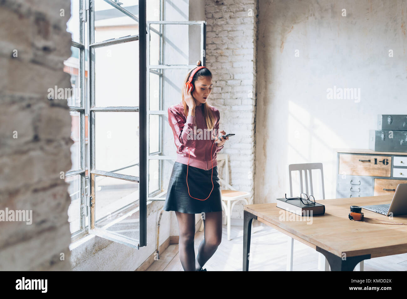 young woman indoors listening music using smart phone - technology ...
