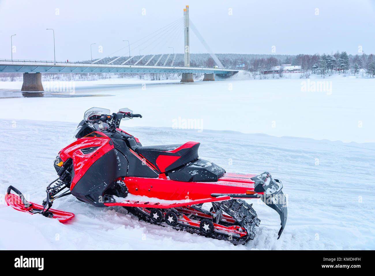 Red snowmobile on frozen lake at Candle bridge in winter Rovaniemi ...