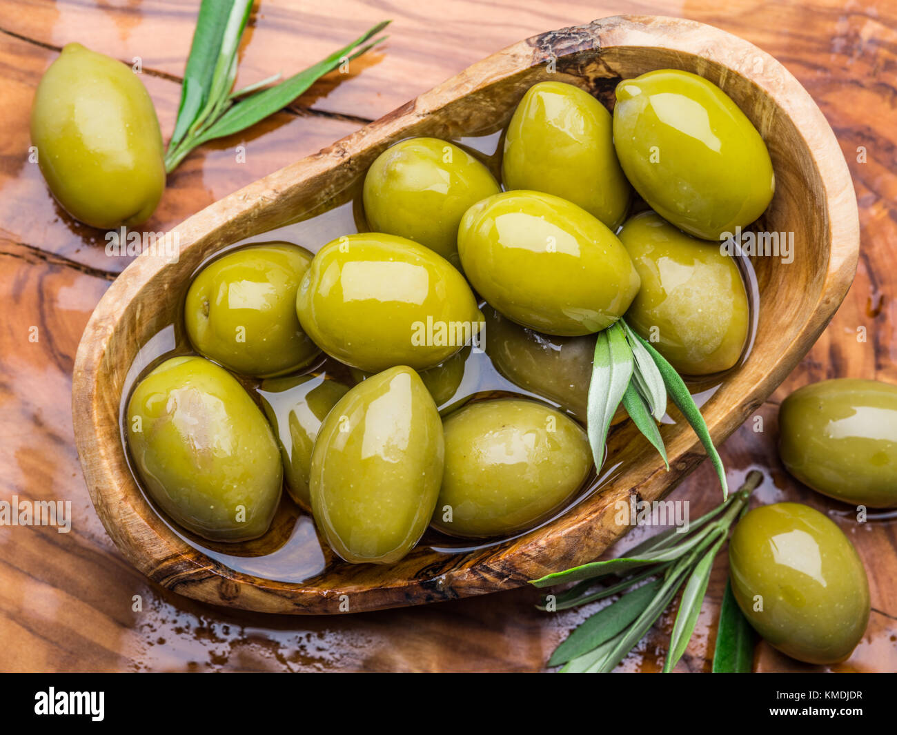Whole table olives in the wooden bowl on the table. Top view Stock ...