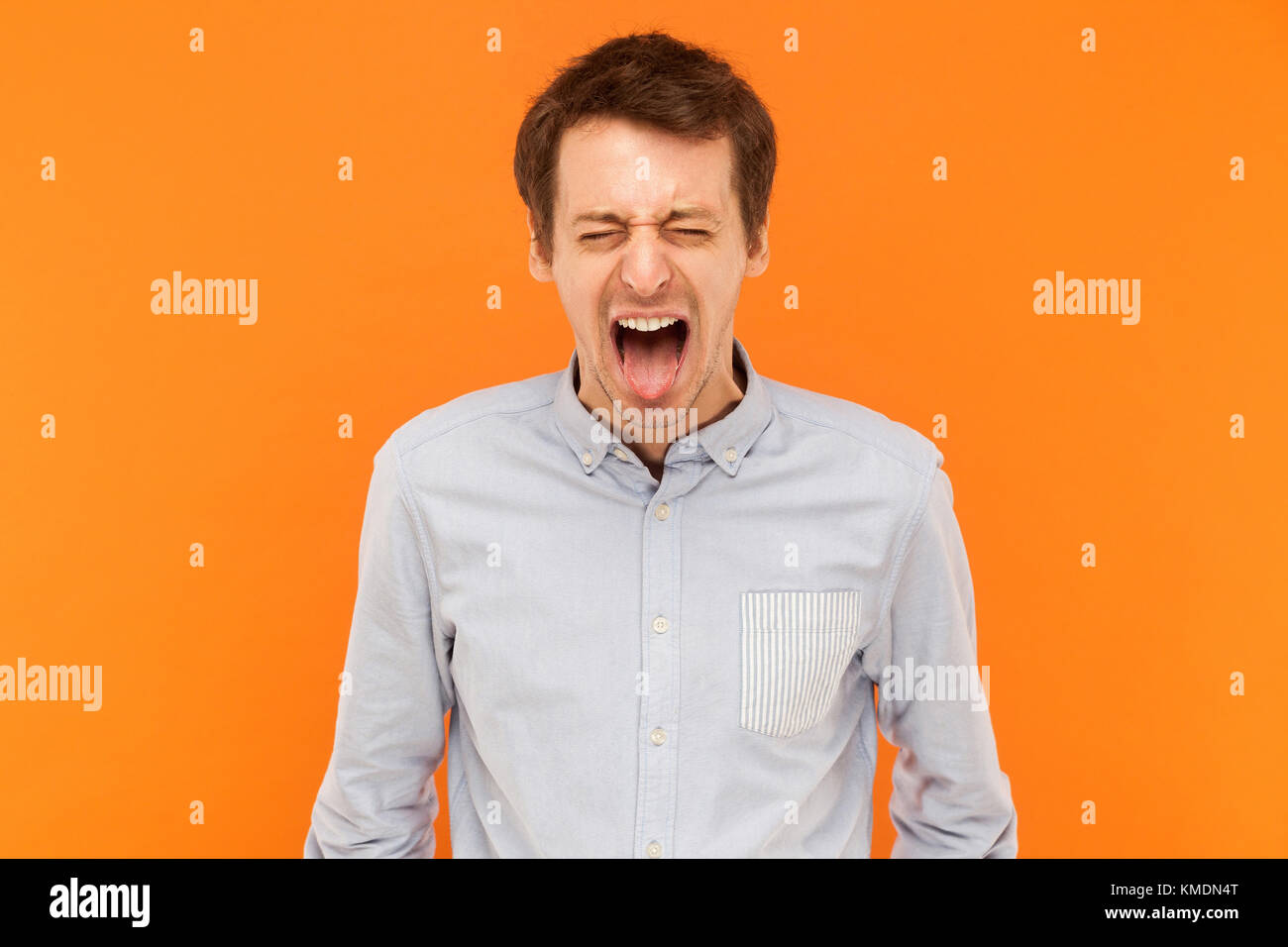 Man closed eyes and tongue out. Studio shot, orange wall Stock Photo ...