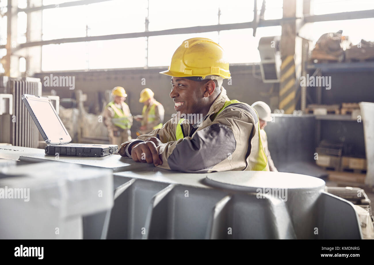 Smiling steelworker looking away in steel mill Stock Photo - Alamy