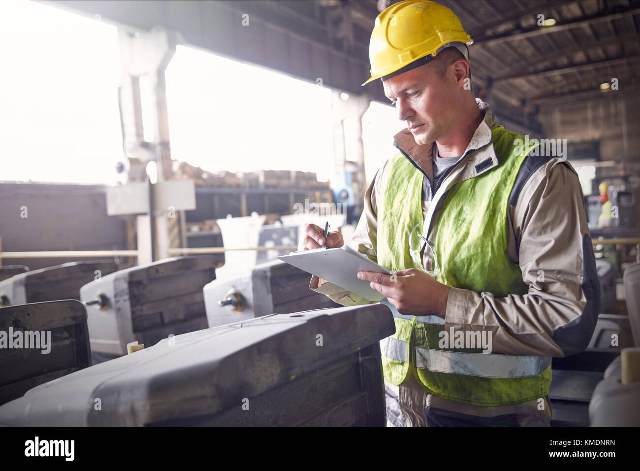Steelworker writing on clipboard in steel mill Stock Photo - Alamy
