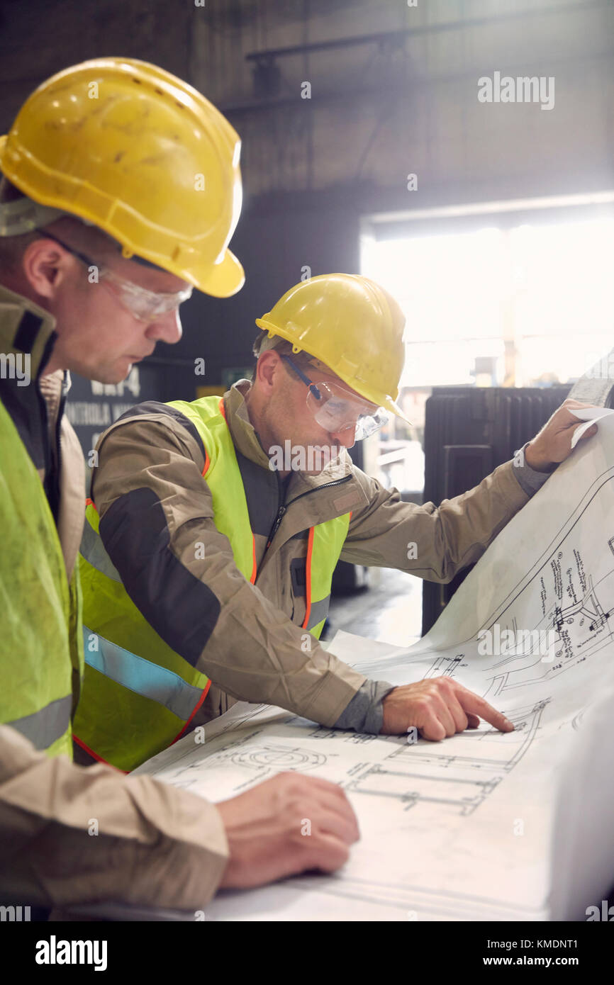 Engineer and steelworker discussing blueprints in steel mill Stock ...