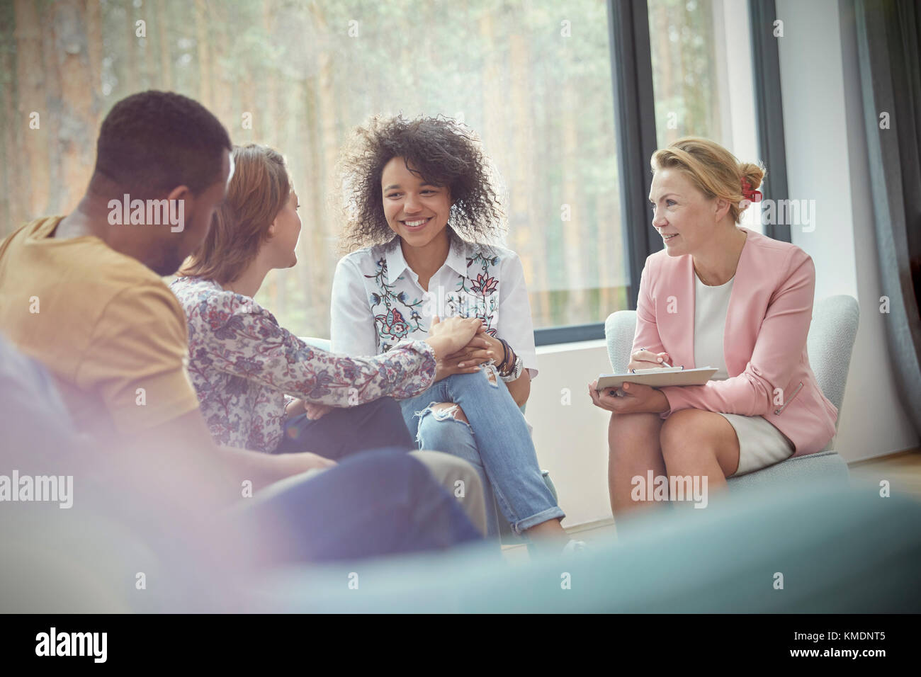 Smiling woman comforting woman in group therapy session Stock Photo - Alamy
