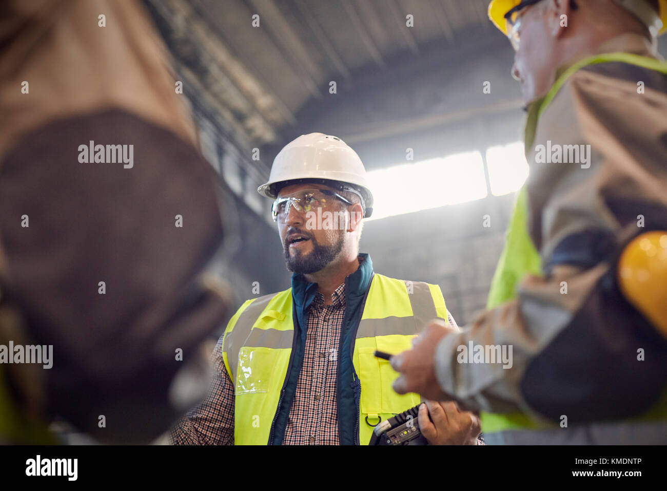 Supervisor talking to steelworkers in steel mill Stock Photo - Alamy