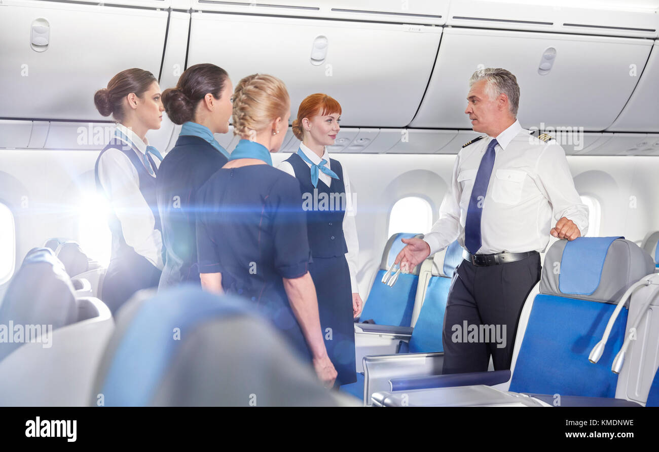Pilot and flight attendants talking,preparing on airplane Stock Photo ...