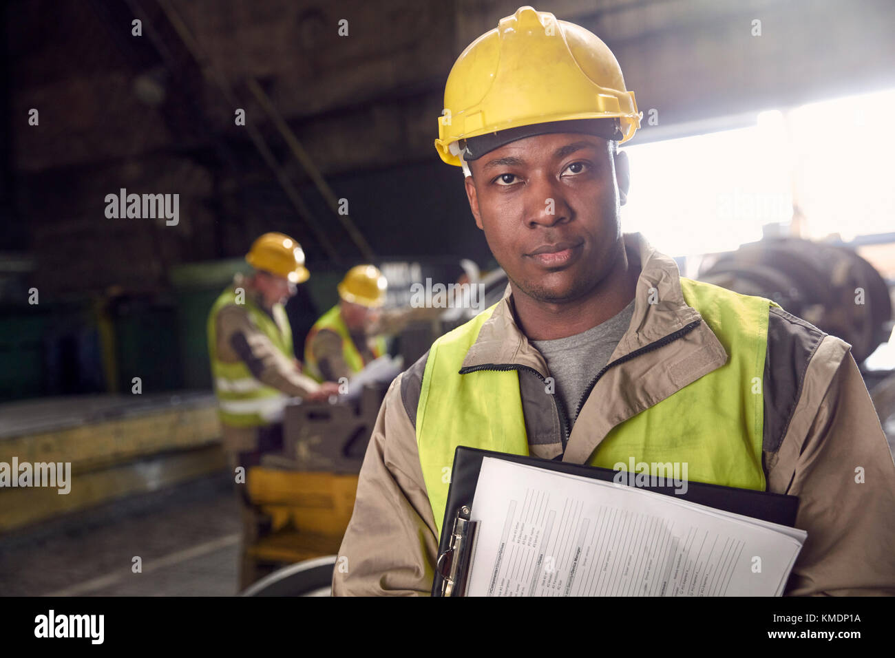 Portrait serious,confident steelworker with clipboard in steel mill ...