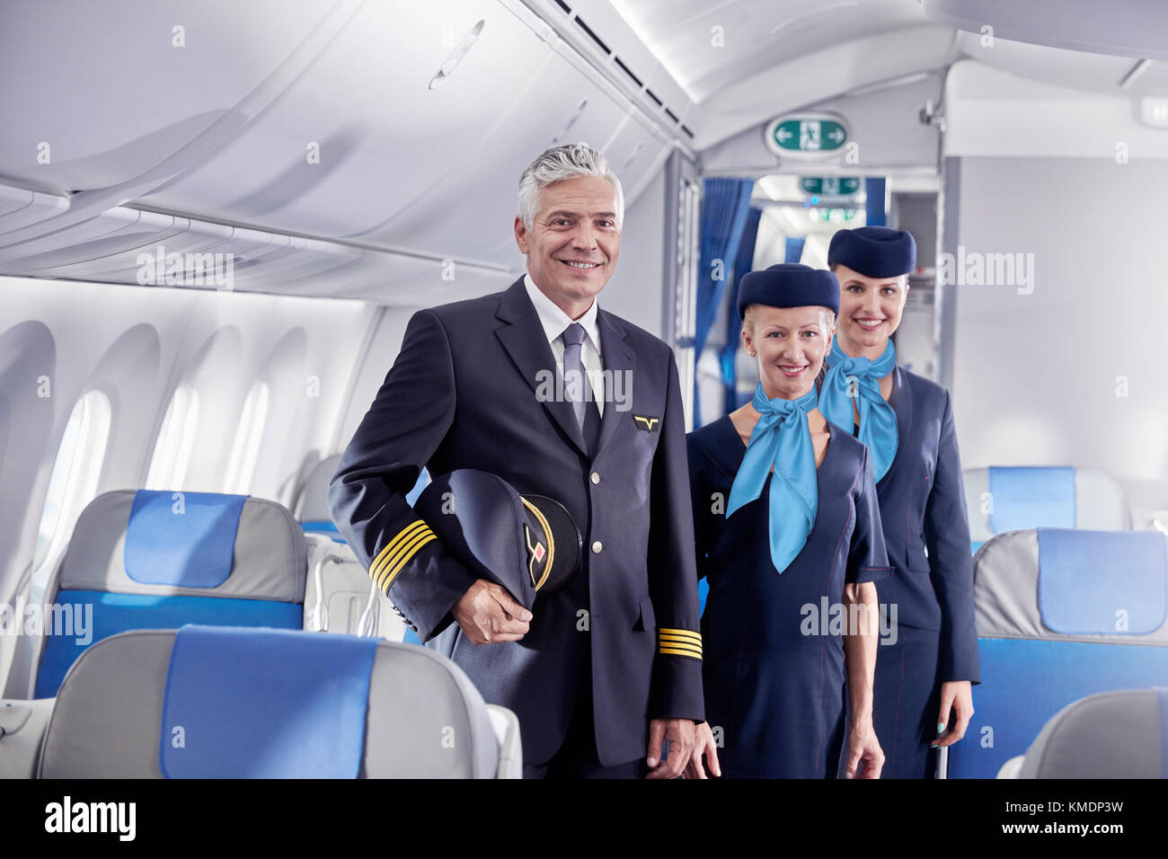 Portrait confident pilot and flight attendants on airplane Stock Photo ...