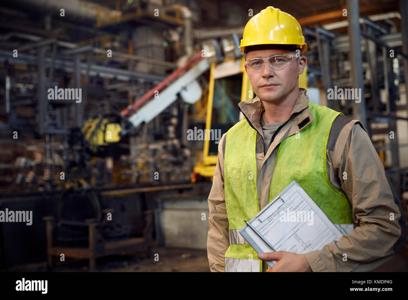 Portrait serious,confident steelworker with clipboard in steel mill ...