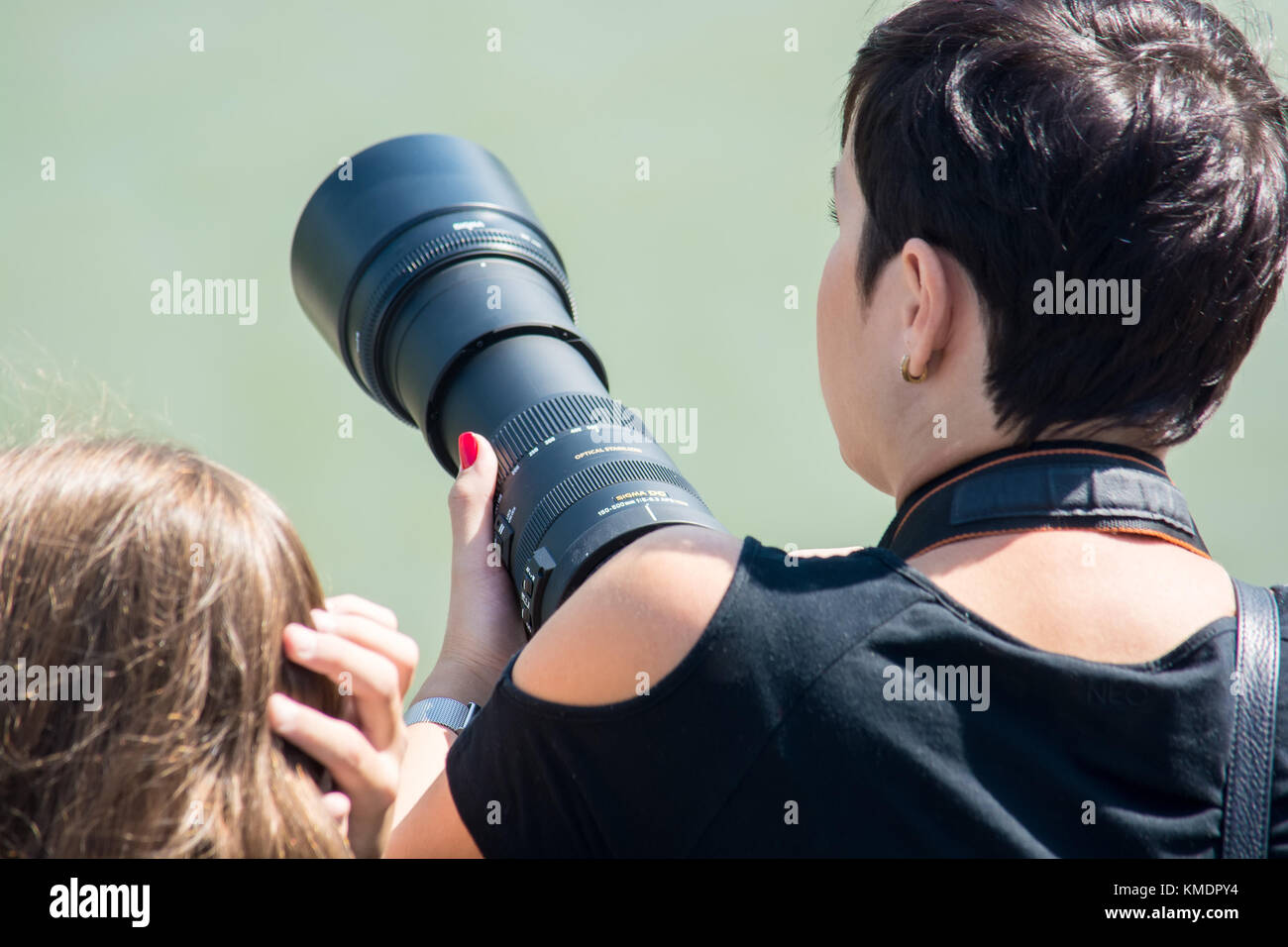 Back view woman with professional camera Stock Photo - Alamy