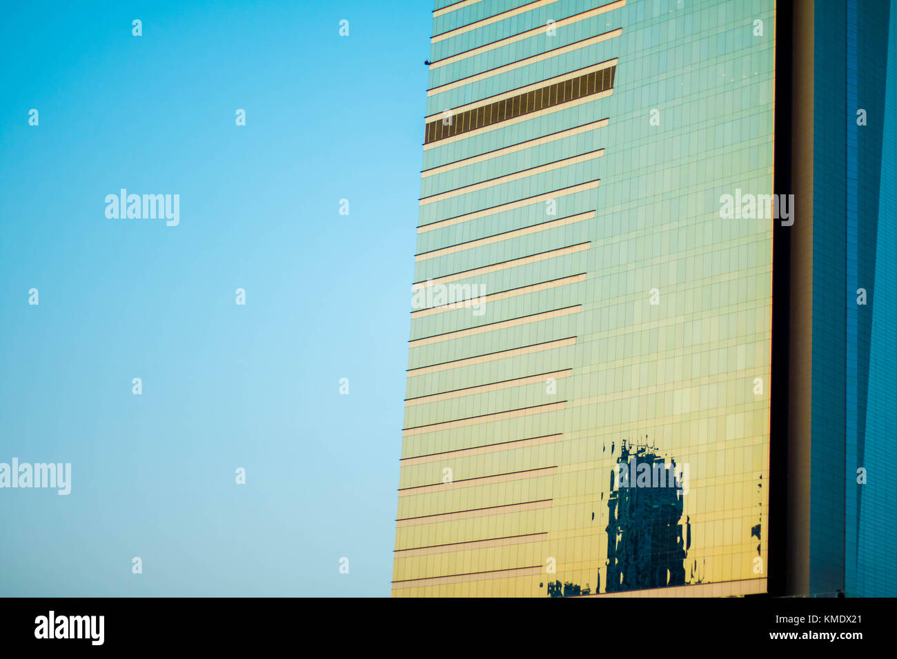 Reflection of a distant building on another building during sunset in ...