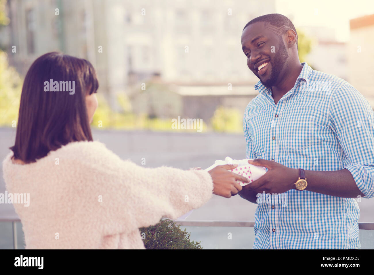 Positive young woman taking a present Stock Photo - Alamy