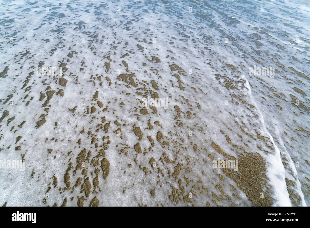 foam of a wave on the beach for backgrounds Stock Photo - Alamy