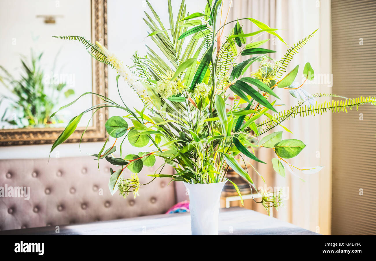 Beautiful green bunch with various plants leaves in vase at room ...
