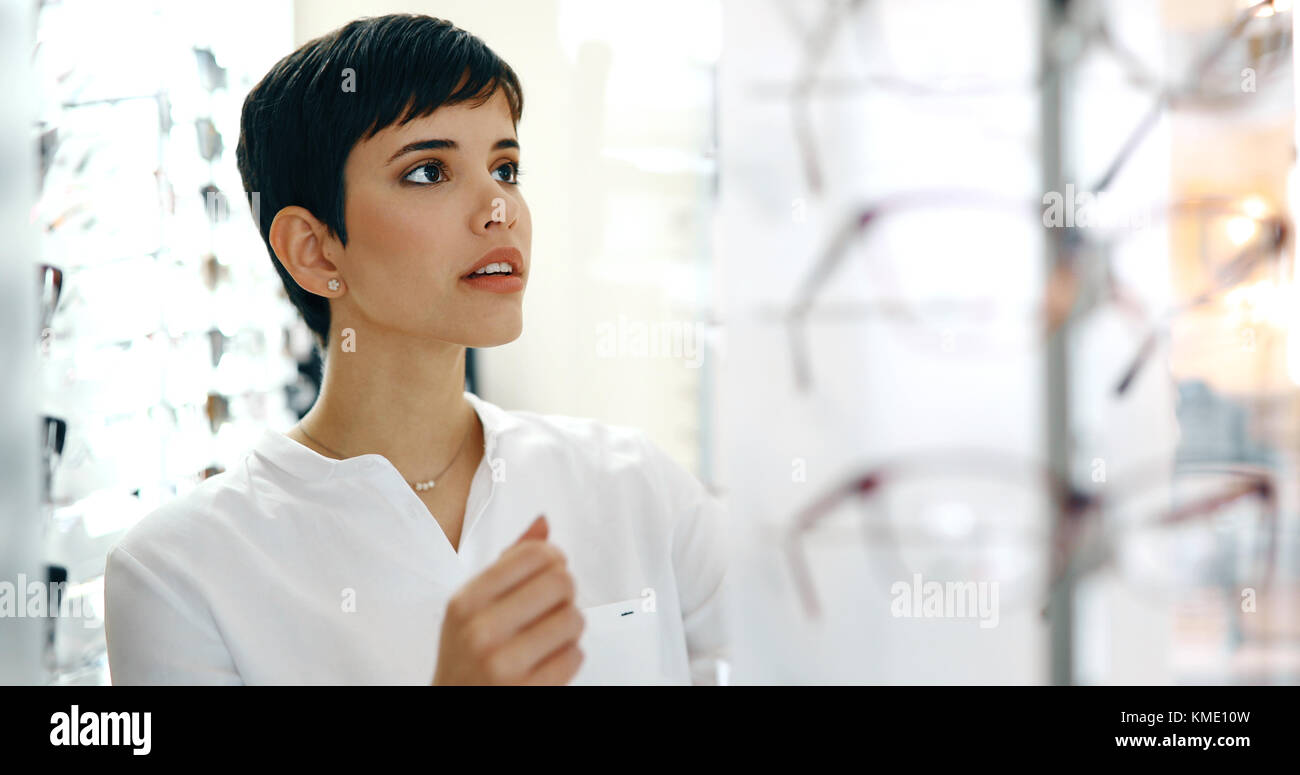 health care, eyesight and vision concept - happy woman choosing glasses ...