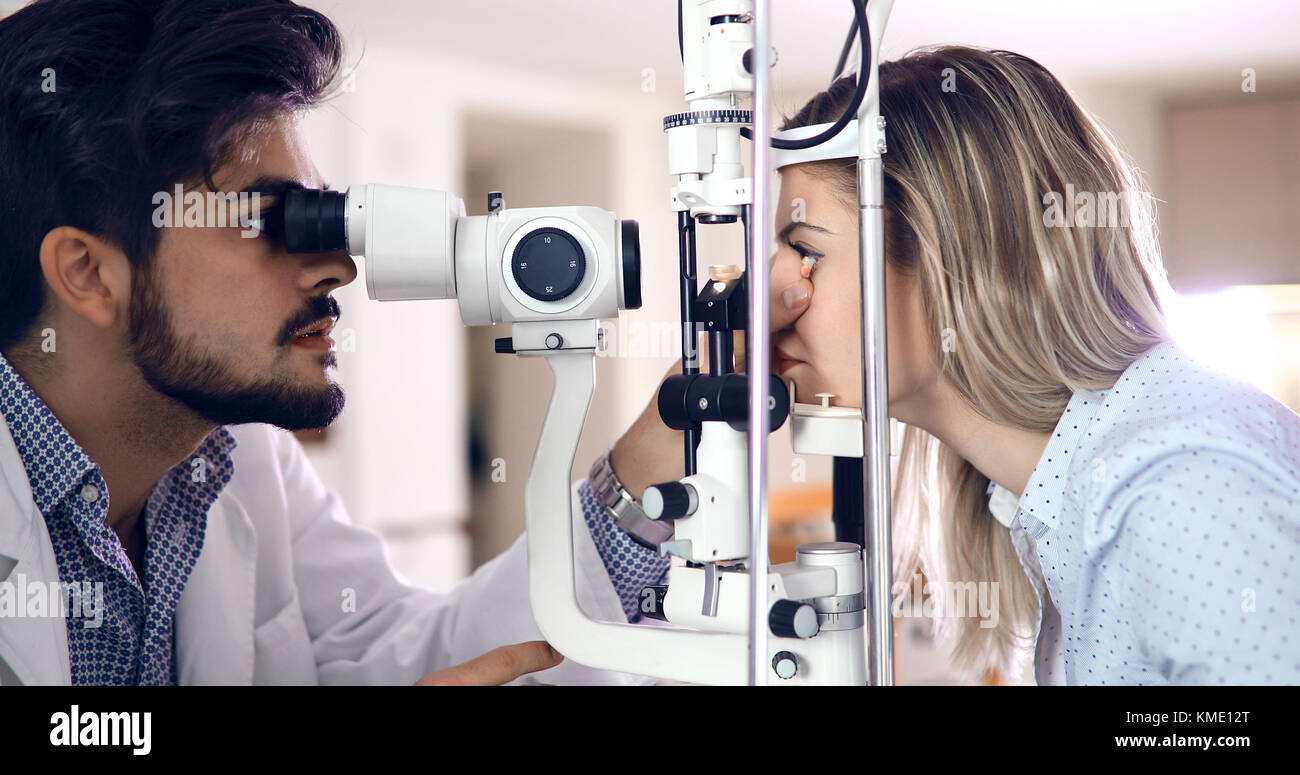 Attentive optometrist examining female patient on slit lamp Stock Photo - Alamy