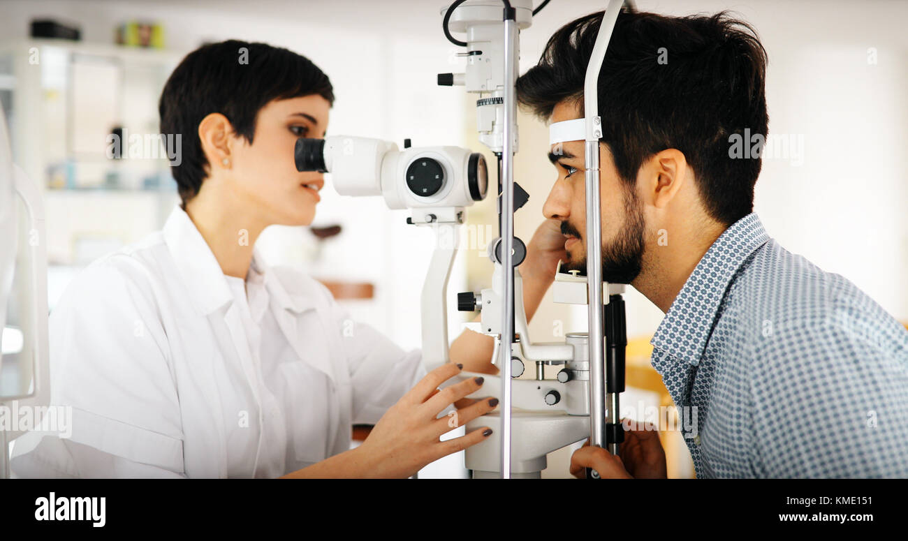 Patient or customer at slit lamp at optometrist or optician Stock Photo ...