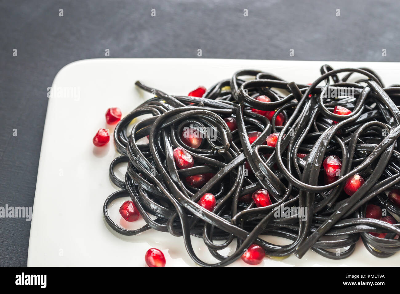 Black pasta with pomegranate seeds Stock Photo - Alamy