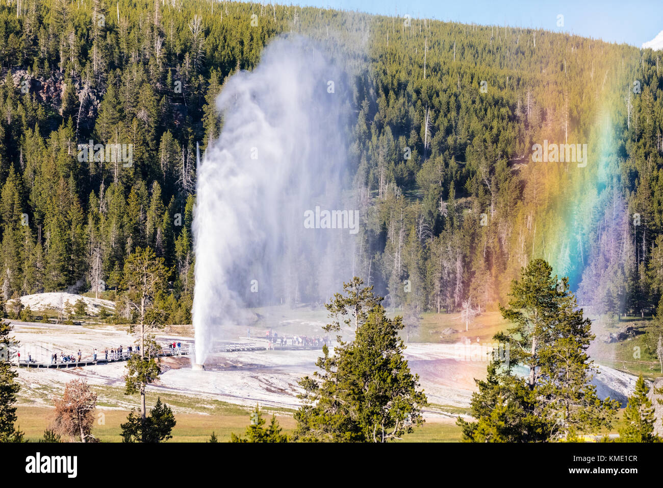 Tourists on the boardwalk watch as the Beehive Geyser in the Upper ...