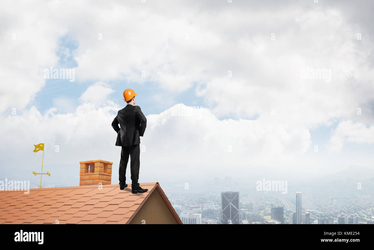 Engineer man standing on roof and looking away. Mixed media Stock Photo ...