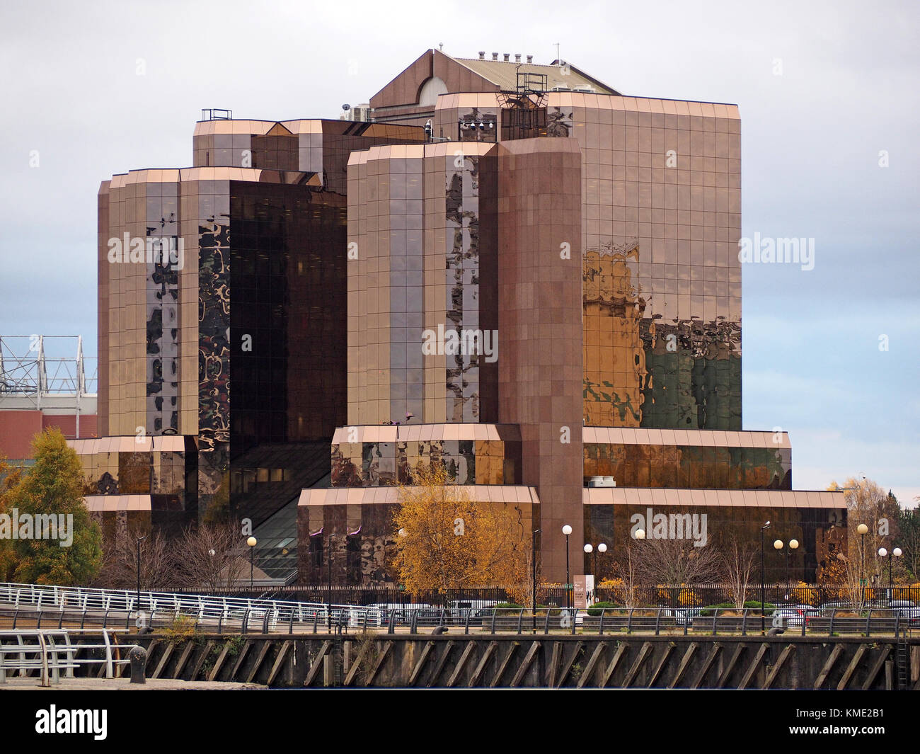 distorted reflections of nearby buildings in bronze glazed facade of ...