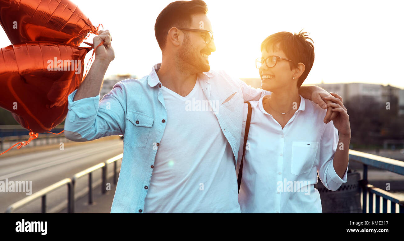 Couple in love cuddling while enjoying beautiful urban sunset together ...