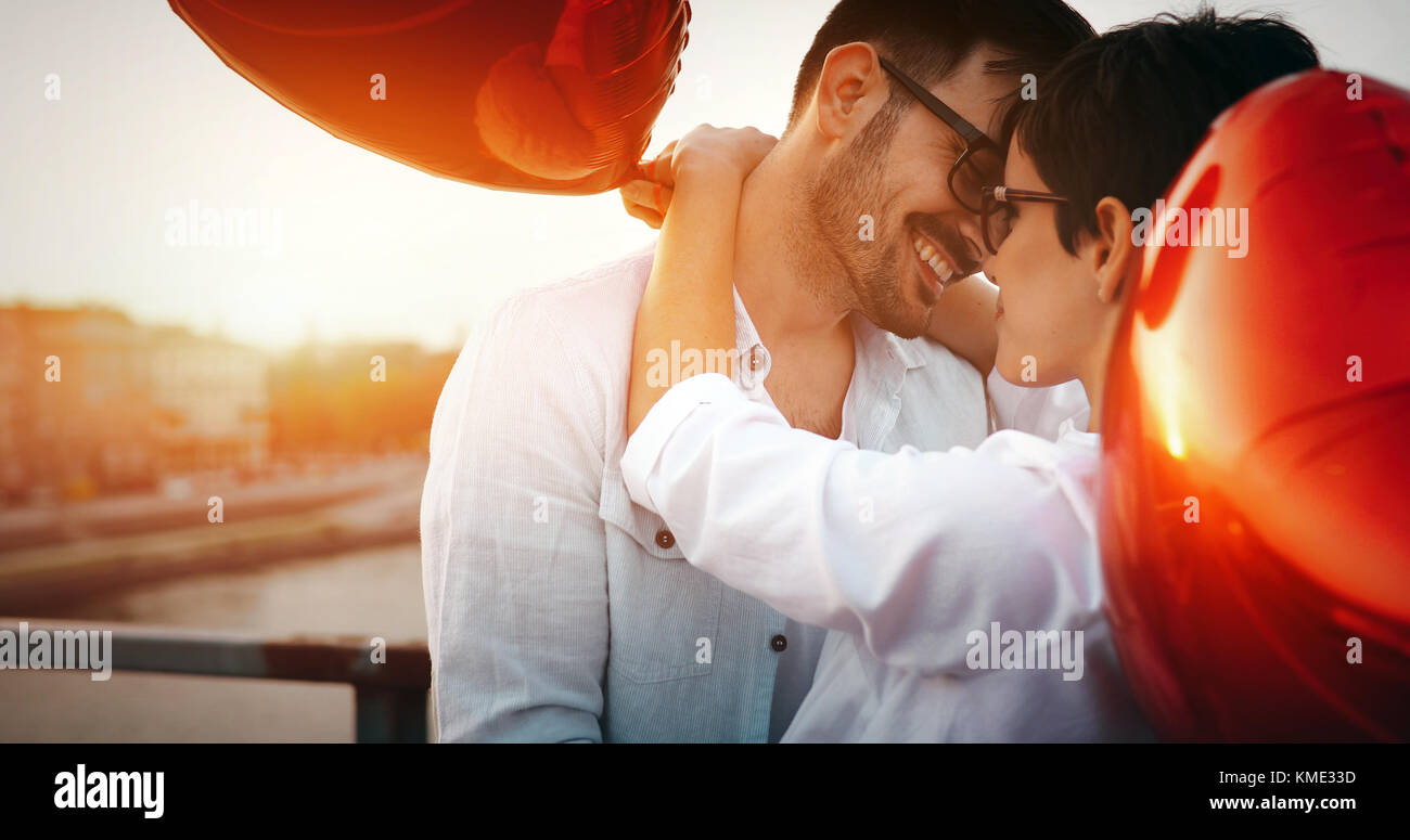 Couple in love cuddling while enjoying beautiful urban sunset together ...