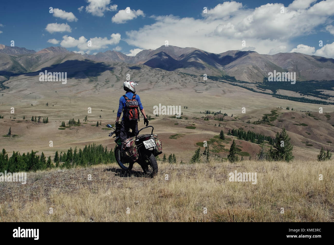 Motorcycle traveler man in helmet with suitcases standing on extreme ...