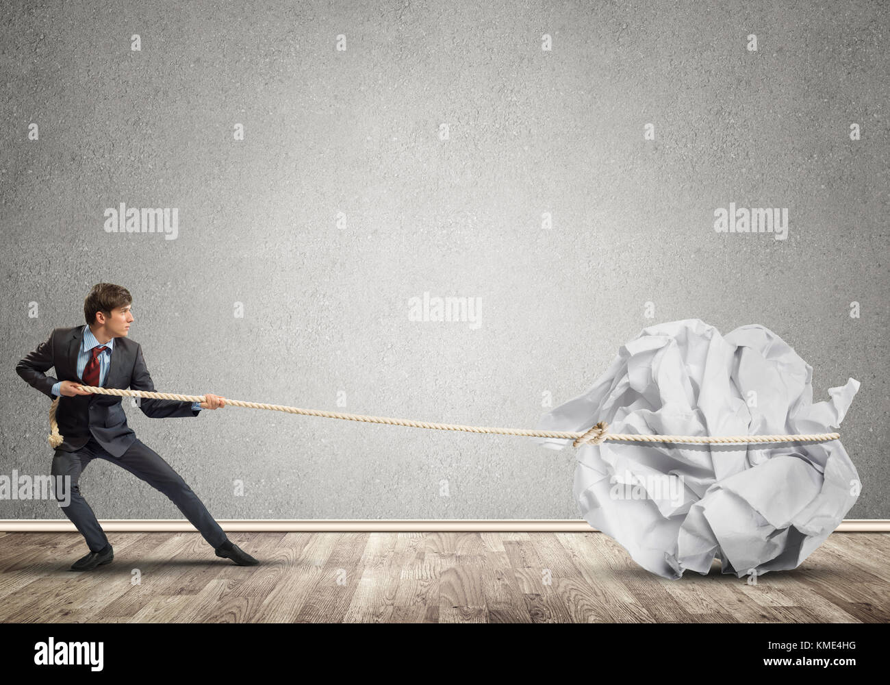 Man pulling with effort big crumpled ball of paper as creativity sign ...