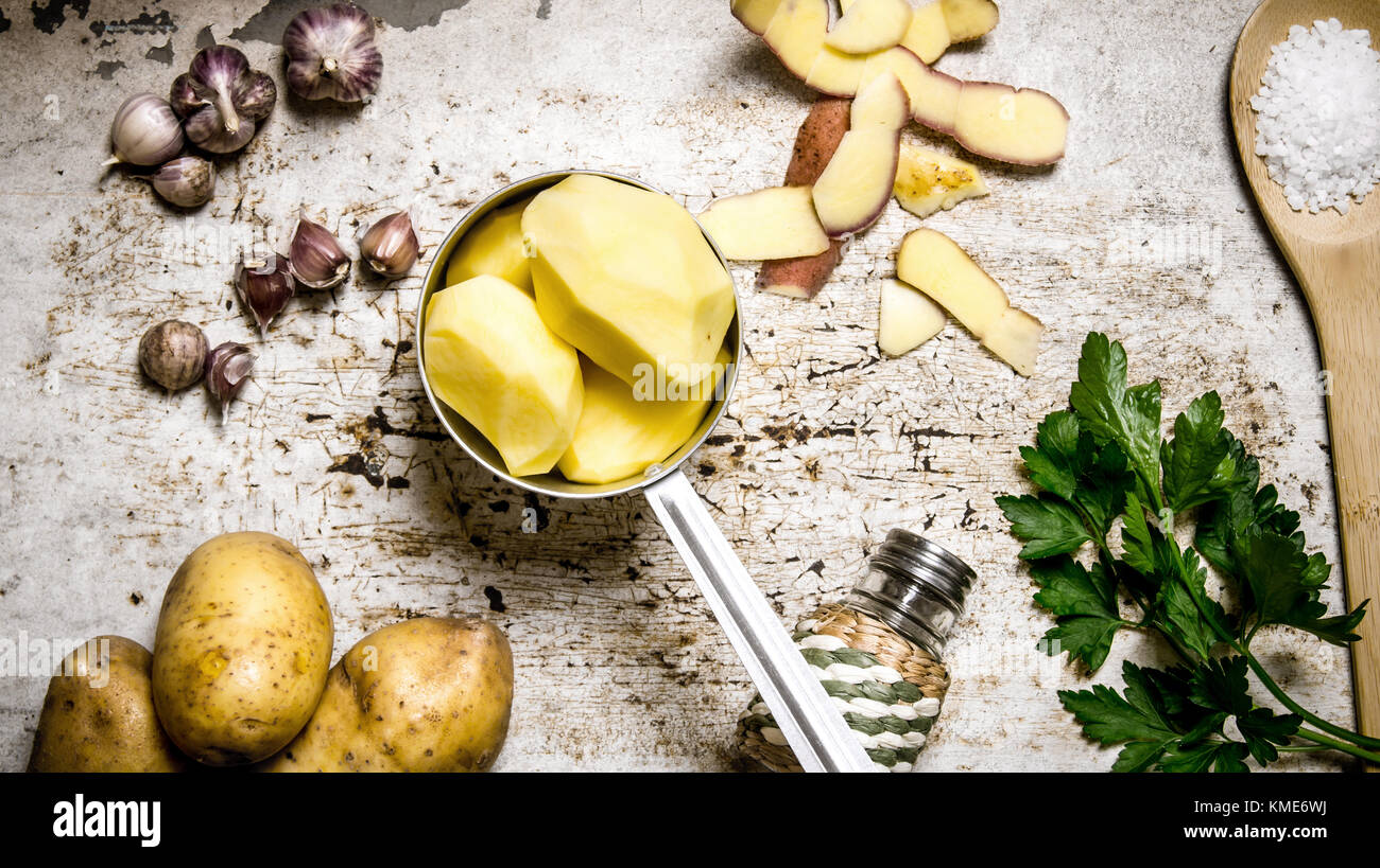 Potato food . The concept of a peeled potato in the pot on the rustic ...