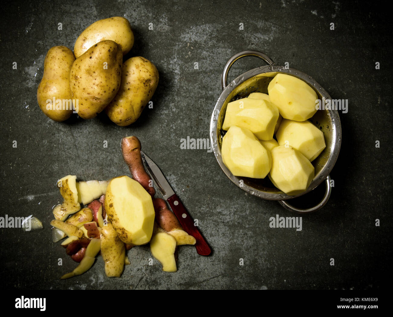 Potato food . The concept of wet peeled potatoes on the stone table ...
