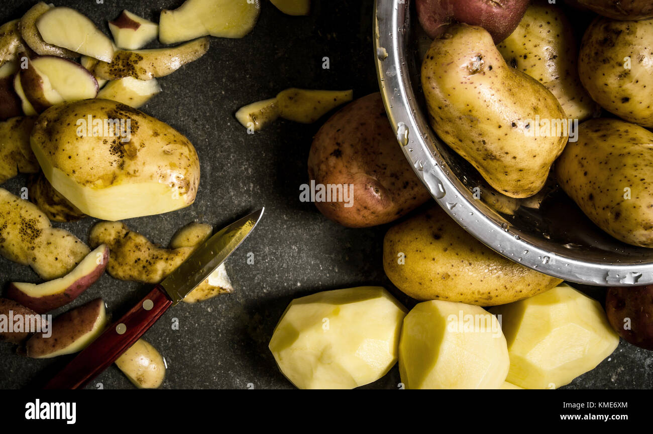 Potato food . The concept of wet peeled potatoes on the stone table ...