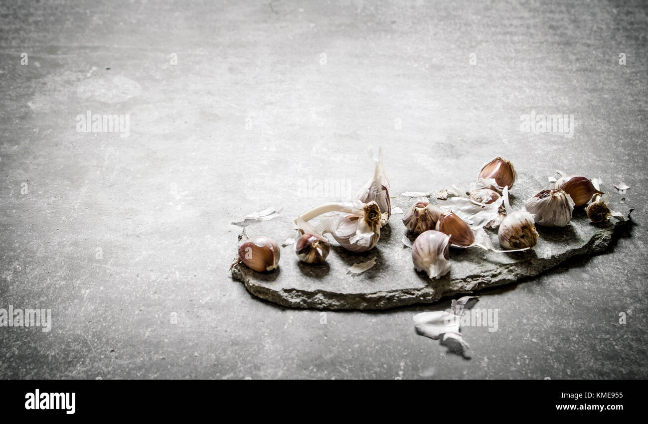 Fresh garlic on a stone stand. On a stone background Stock Photo - Alamy
