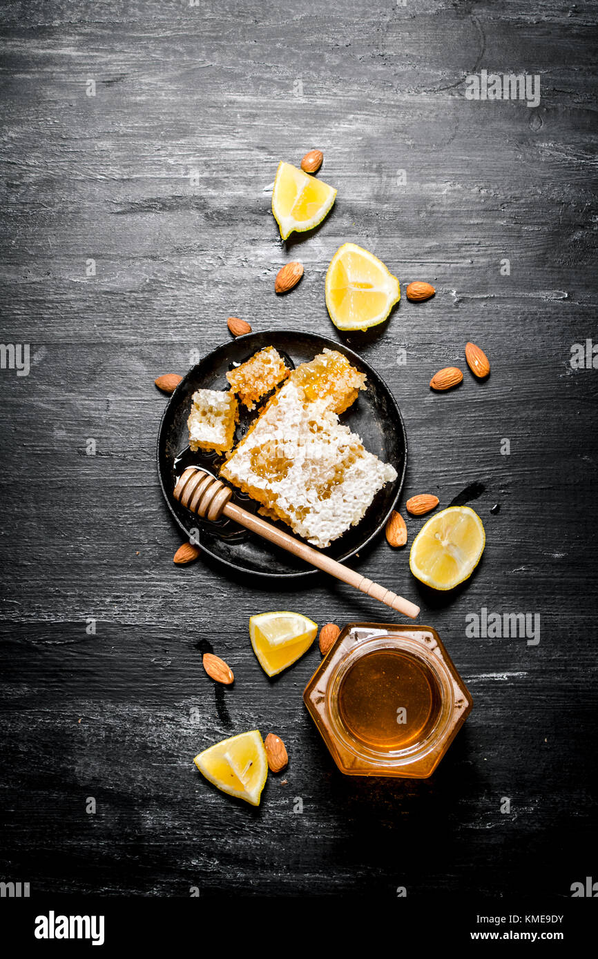 Honey background. Sweet natural honey with lemon . On black rustic ...