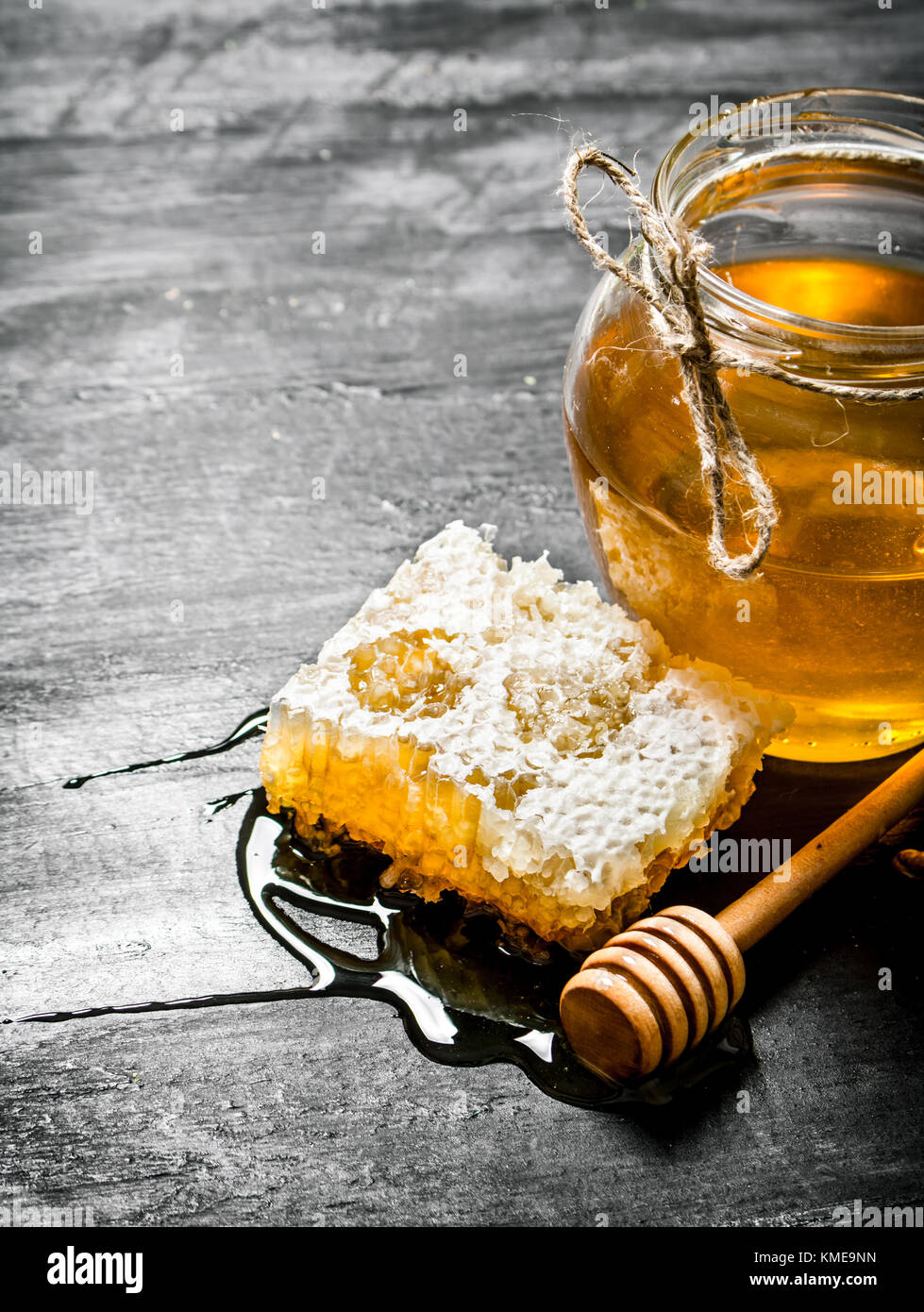 Honey background. Natural honey comb and a glass jar. On black rustic ...