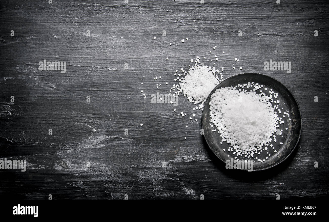 Coarse salt on the old pan. On black rustic background Stock Photo - Alamy
