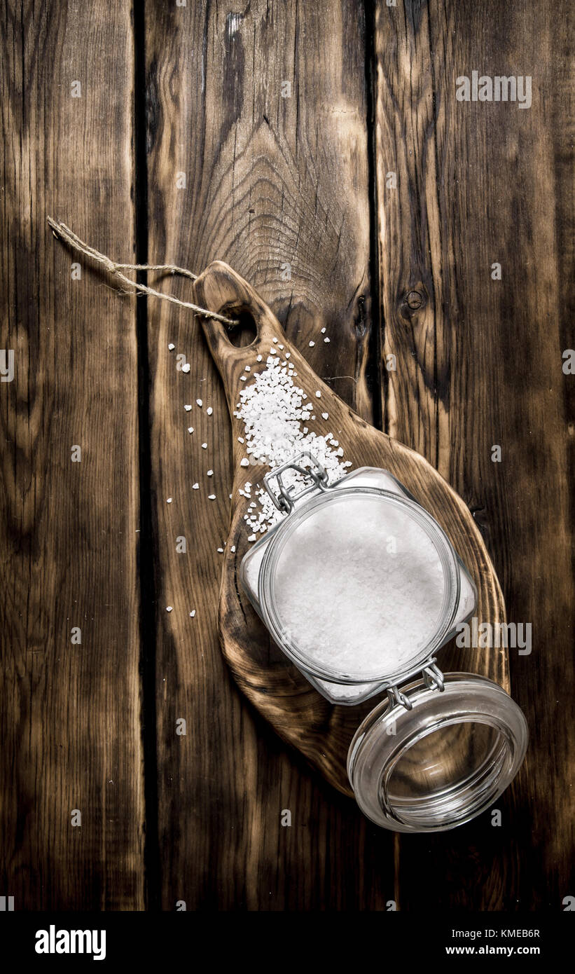Salt in a glass jar on a wooden Board. On a wooden background Stock ...