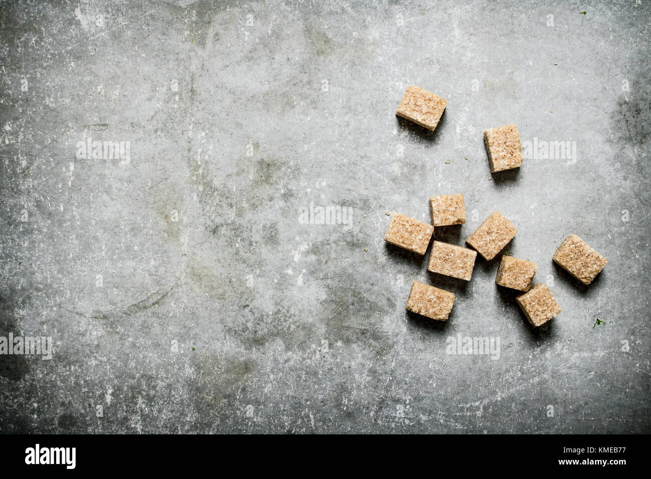 Dark cane sugar is refined. On a stone background Stock Photo - Alamy